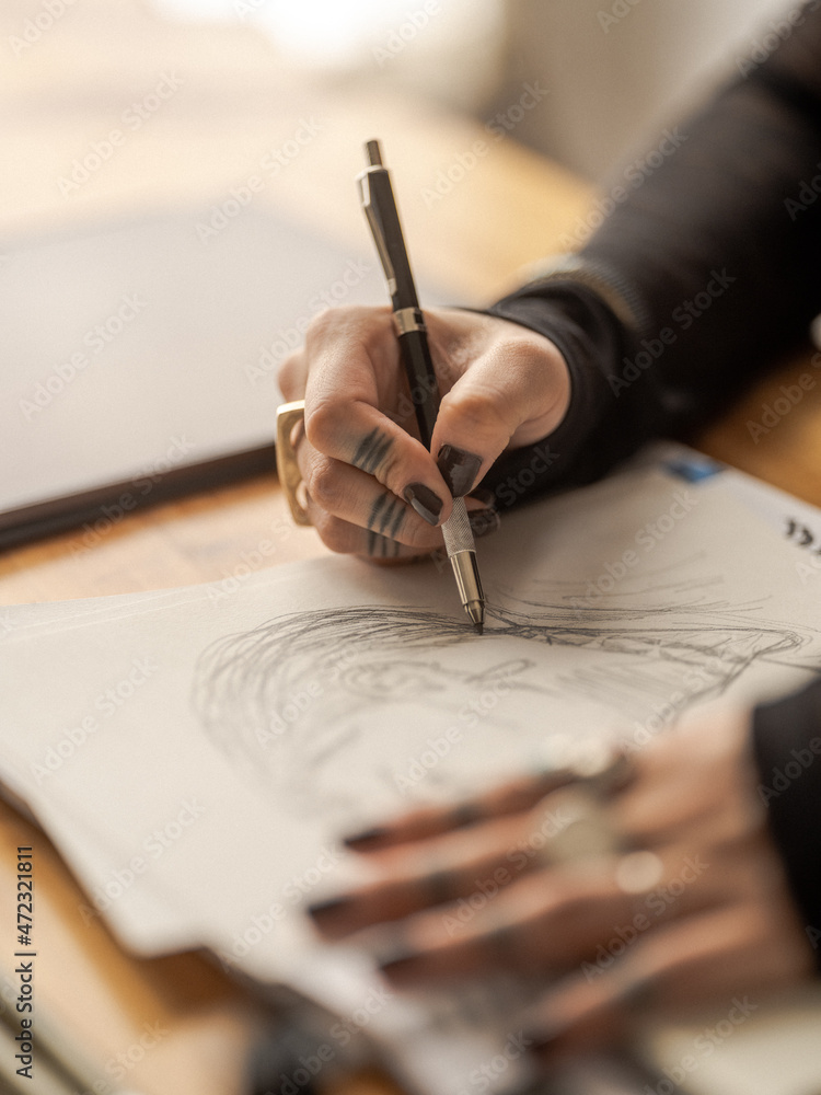 Non binary Indigenous artist drawing indoors Stock Photo | Adobe Stock