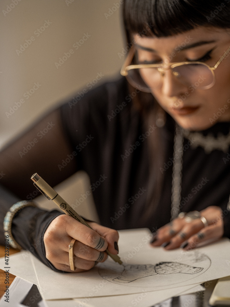 Non binary Indigenous artist drawing indoors Stock Photo | Adobe Stock