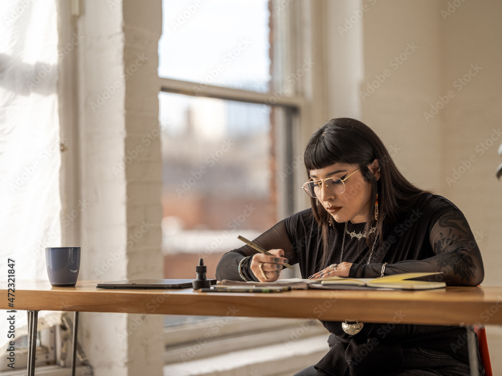 Non binary Indigenous artist drawing indoors Stock Photo | Adobe Stock