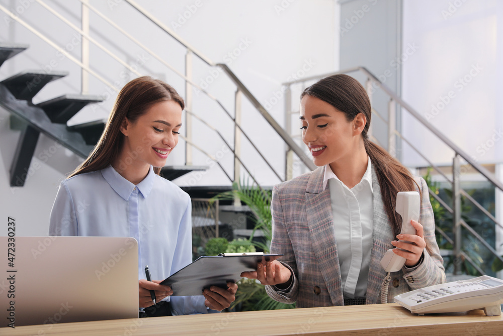 Female receptionists working at desk in hotel Stock Photo | Adobe Stock