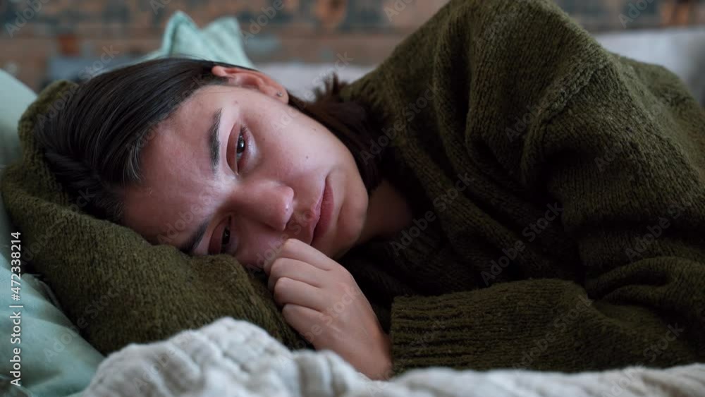 Sad frustrated young woman, lying on bed, loft design, have depression ...