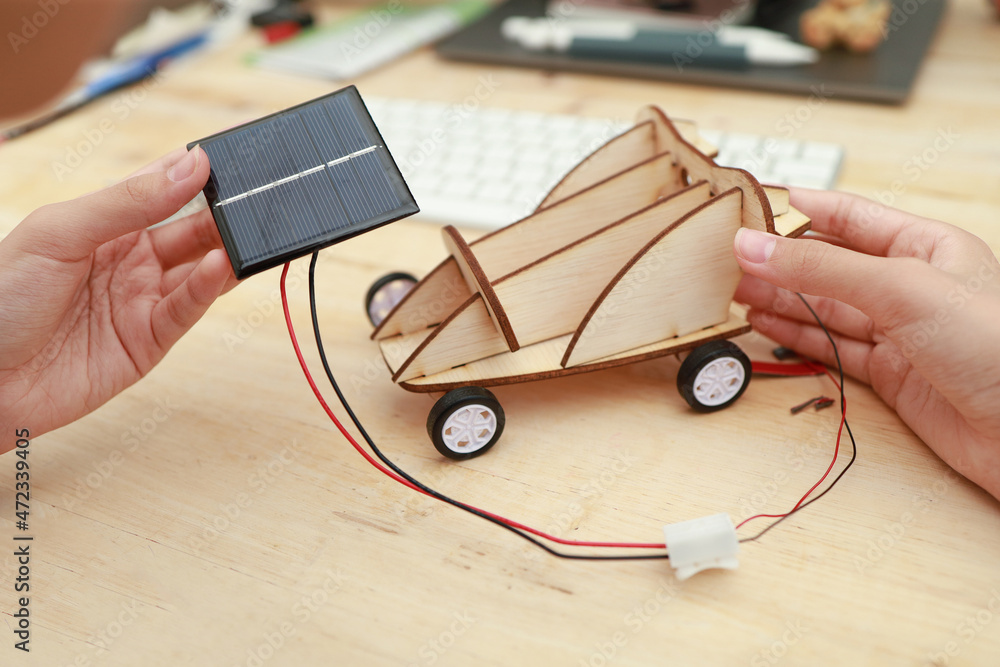 Kid assembly a solar toy car through online e-learning at home. Student ...