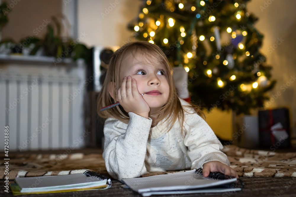 Cute baby girl in white sweater write a letter to Santa and thinking ...