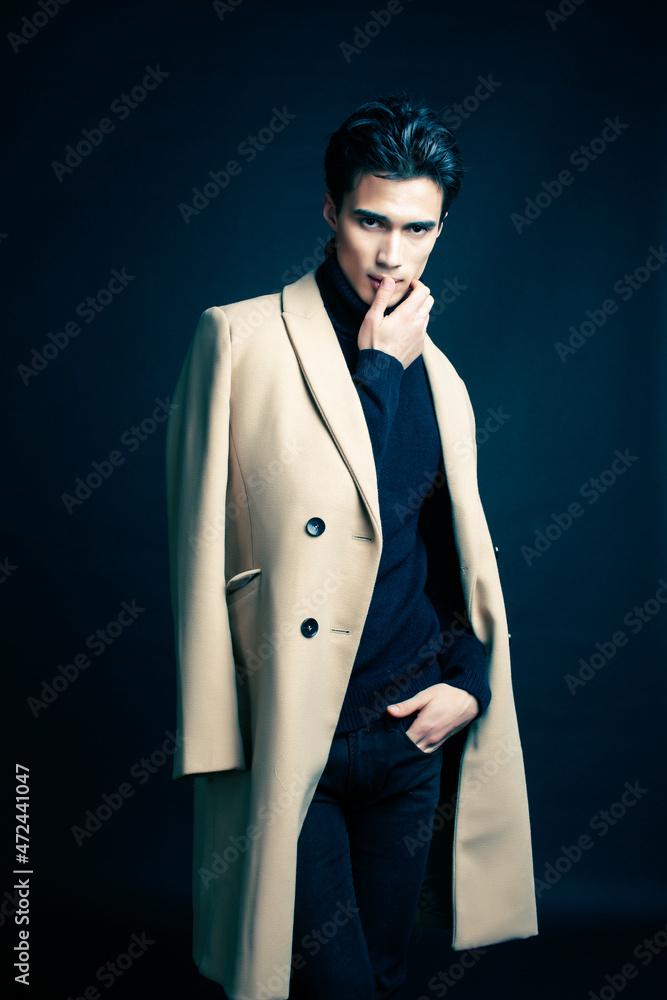 handsome asian fashion looking man posing in studio on black background ...