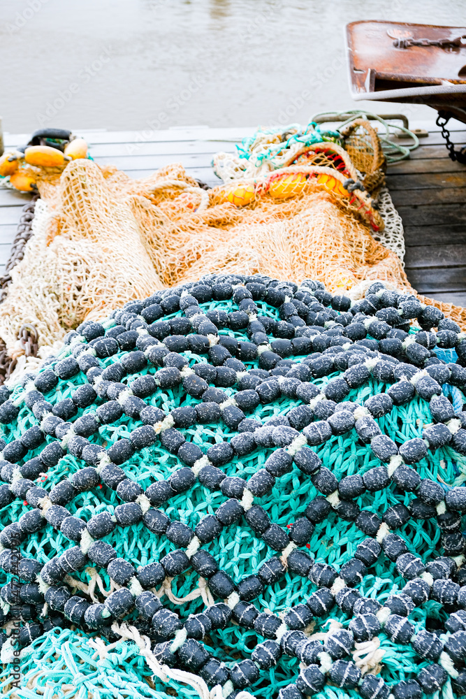 blue fishing net on a pontoon with its ropes and floats covered with ...