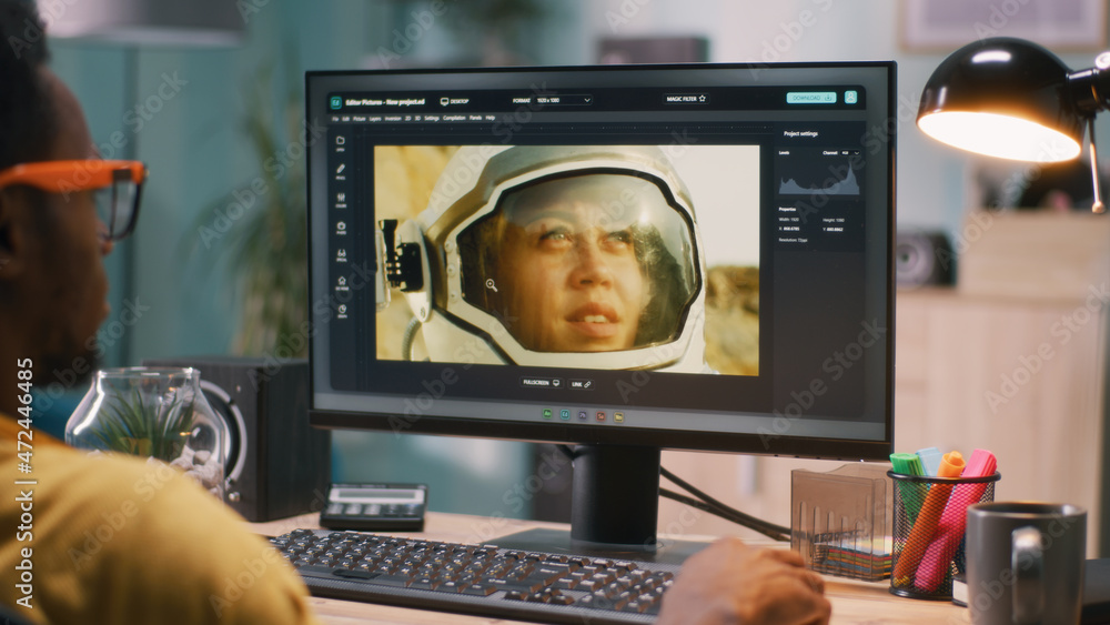 Black man using software on modern computer to edit photo in editing ...