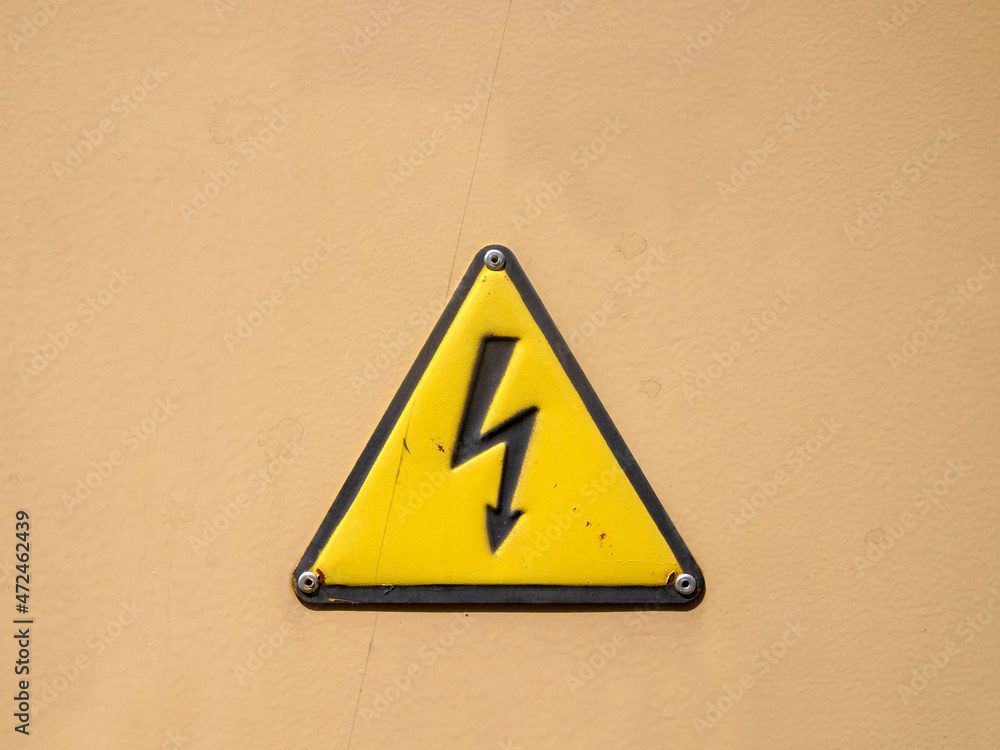 High voltage dangerous electric sign. View of a triangular yellow ... High voltage dangerous electric sign. View of a triangular yellow ...