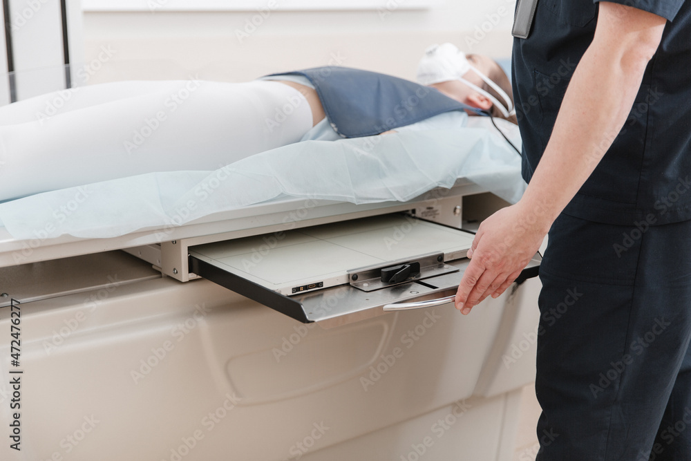 Doctor taking x-ray of patient lying on gurney. Hospital radiology room ...