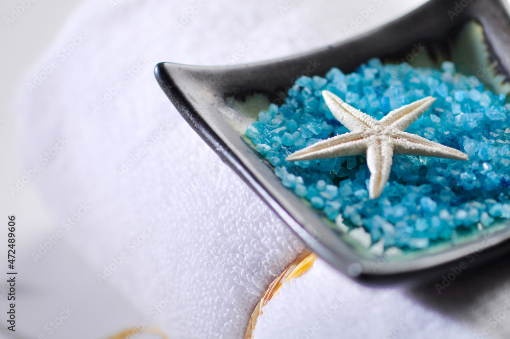 Blue granules of bubble bath soap in a small tray with star fish sea ...