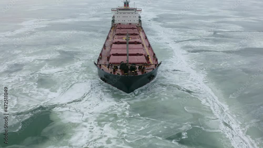 Aerial above epic huge steel icebreaker breaks ice by bow of ship and ...