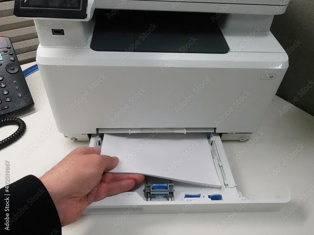 Man loading paper into printer paper tray Stock Photo | Adobe Stock