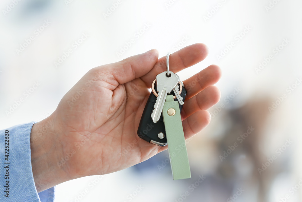 Male hand holding keys on chain Stock Photo | Adobe Stock