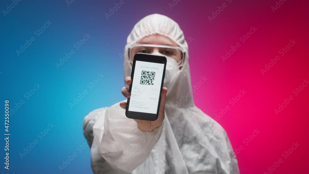 Woman doctor wearing protective uniform showing on phone vaccination ...