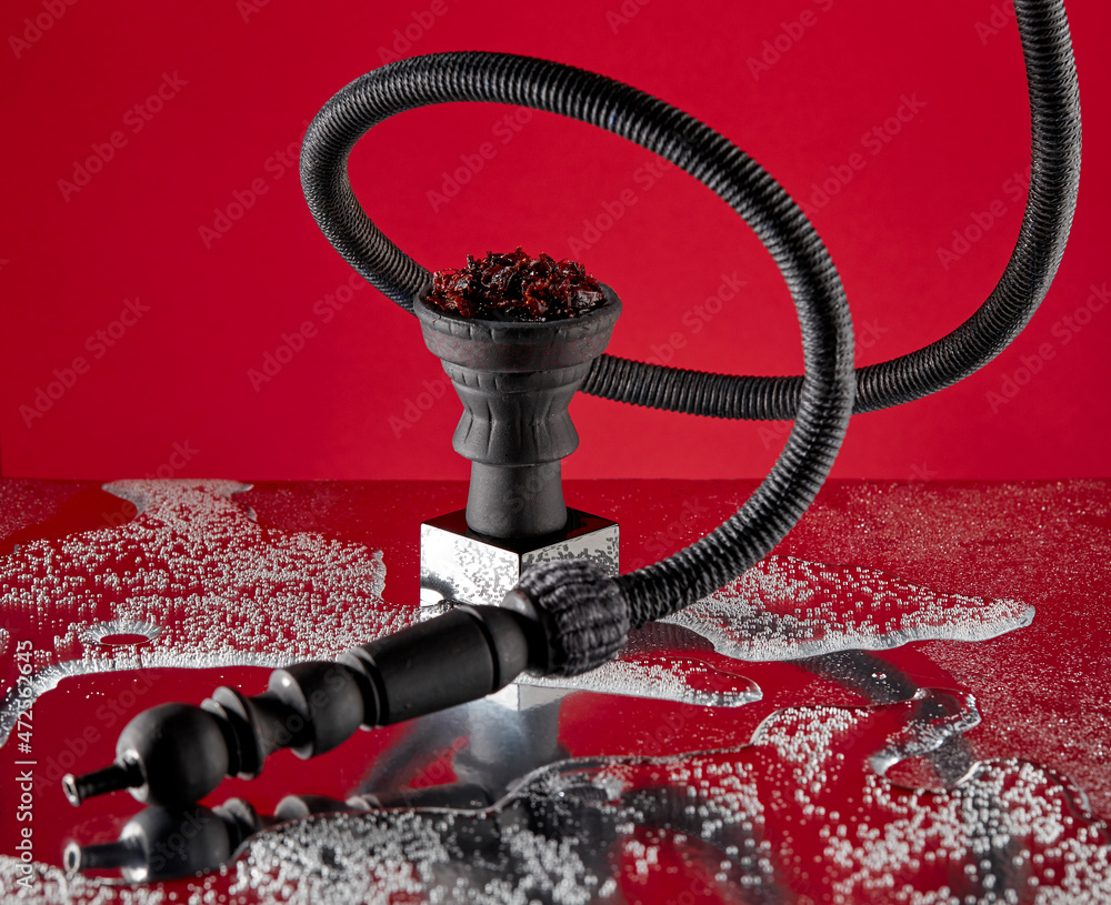 Black ceramic bowl filled with a shisha, on a rectangular pedestal ...