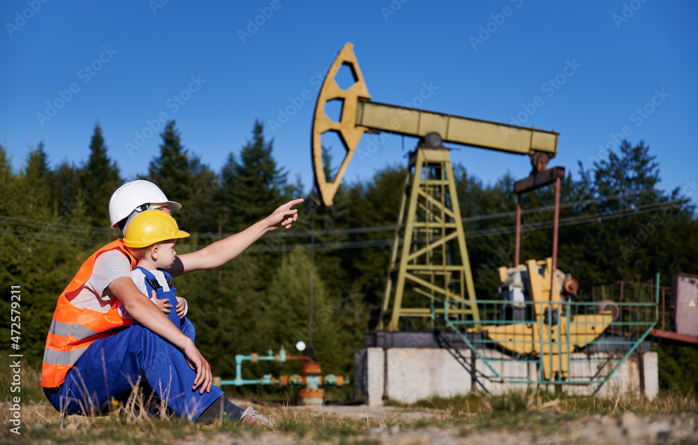 Oil rig operator introducing his son to his profession. Oilman ...