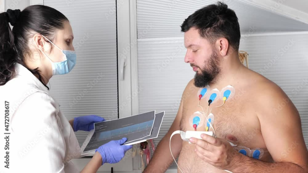 man patient with ECG cardiogram of heart, doctor cardiologist attaches ... man patient with ECG cardiogram of heart, doctor cardiologist attaches ...