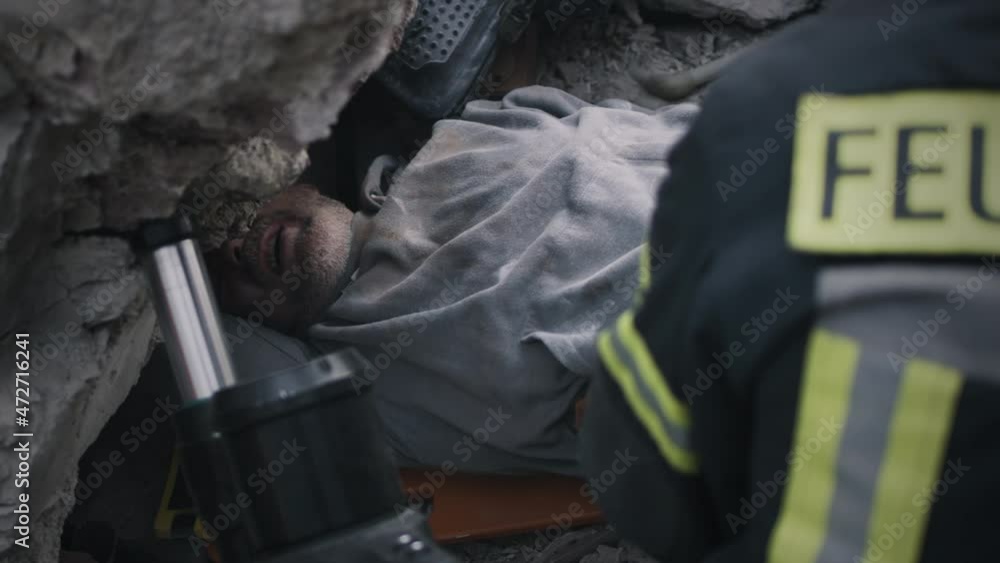 From above crop emergency service workers pulling senior male survivor ...