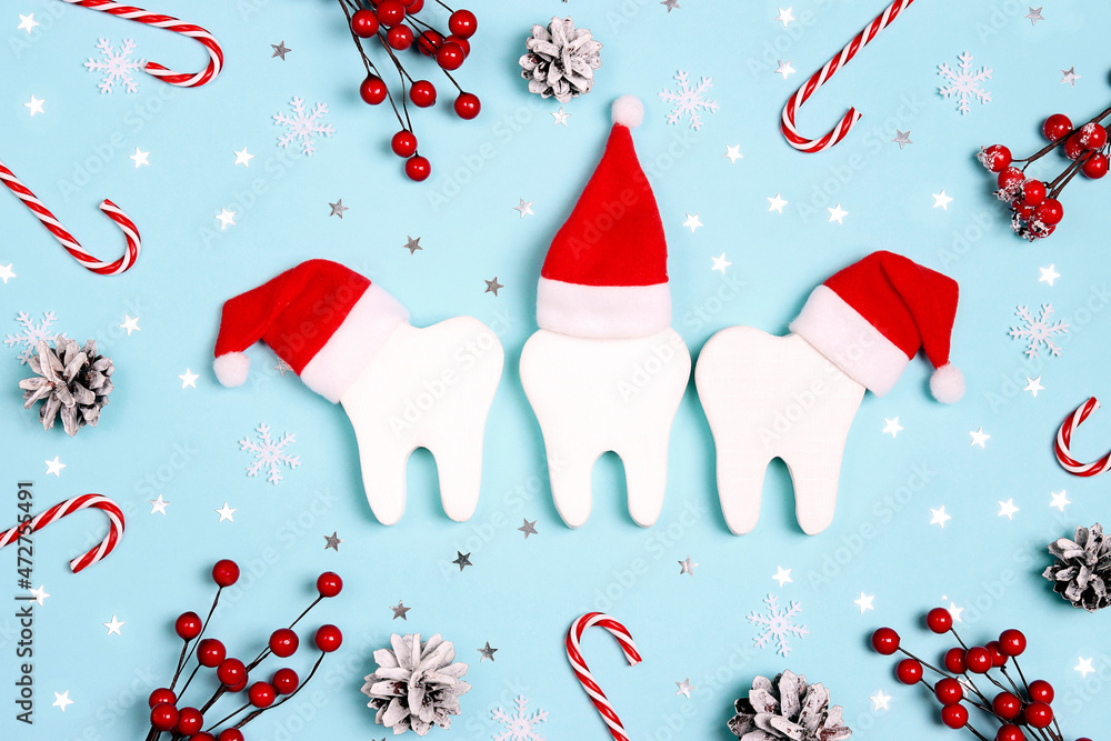 White teeth in santa hats surrounded by christmas decorations on blue ...