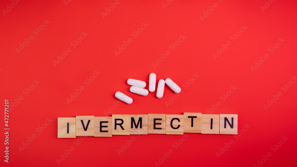 Ivermectin on colored red paper texture background. Ivermectin antiparasitic medication. Off ...