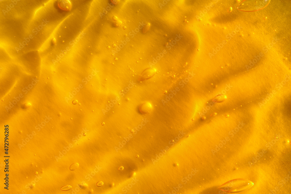 Texture of transparent yellow gel with air bubbles and waves on orange ...