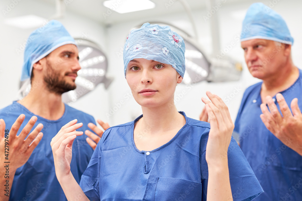 Woman as a surgeon in a lab coat together with a medical team Stock ...