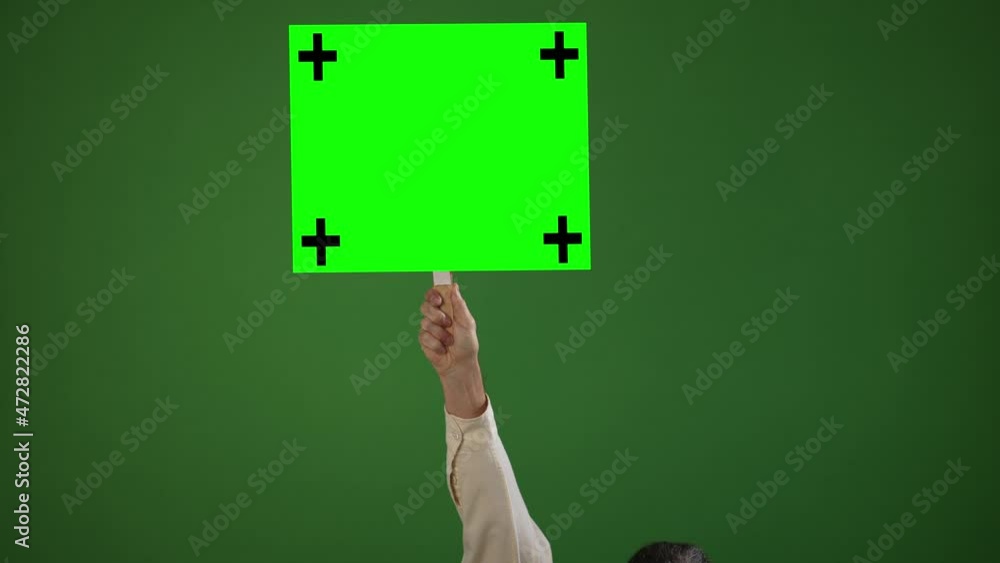 Arm holding a green screen sign with tracking points on a chroma key ...