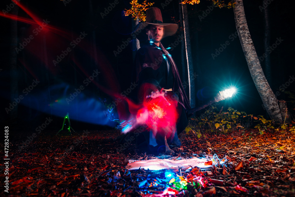 Wizard (mage) casting a spell with his magical staff while standing in ...