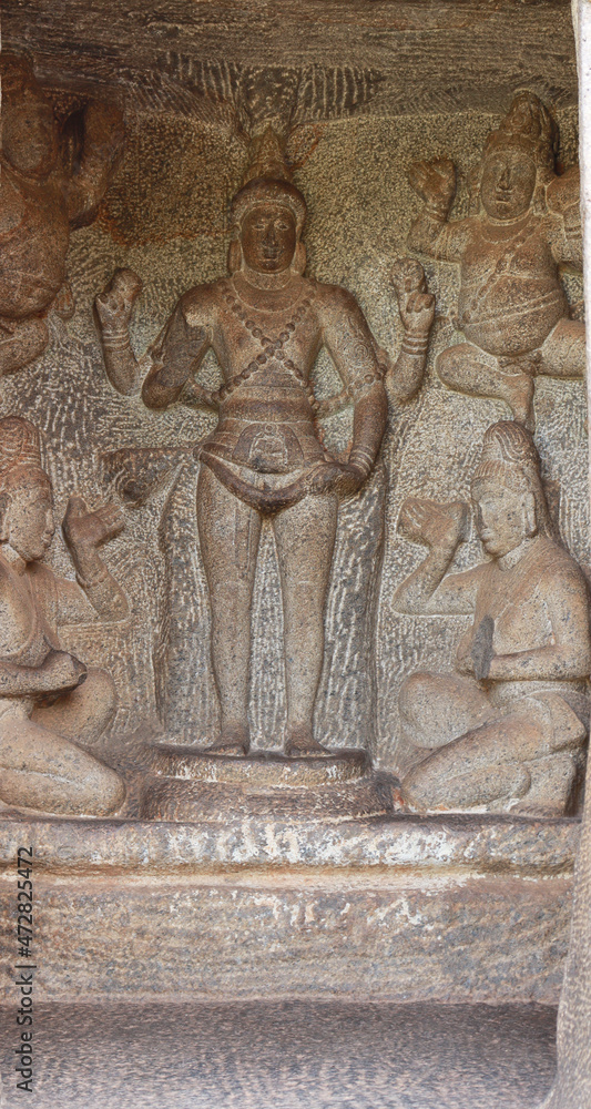Statue of a Hindu god carved in stone. The rock is located in the ...
