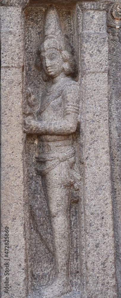 Statue of a Hindu god carved in stone. The rock is located in the ...