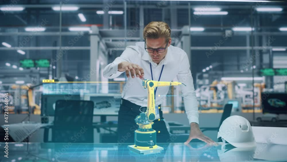 Industry 4.0 High-Tech Factory: Robotics Engineer Working on Robot Arm Design, Using Augmented ...