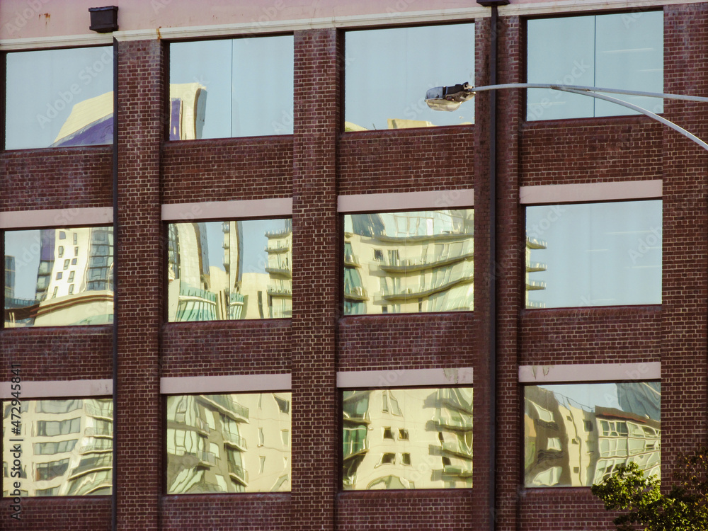 An old red brick factory with 12 square windows. The windows reflect ...