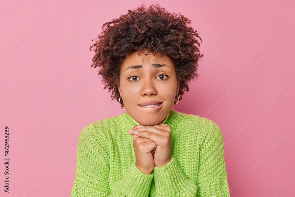 Foto Stock Hopeful worried curly haired young woman keeps hands under ...