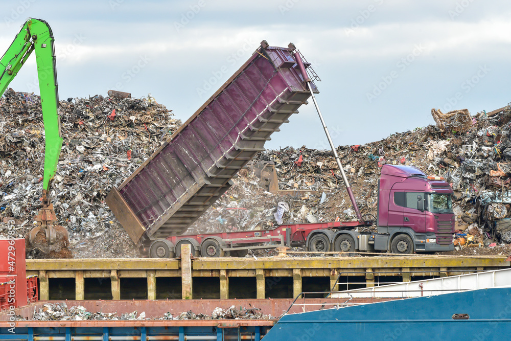 Machine operated grabbing arm, loading scrap metal onto a ship in the ...