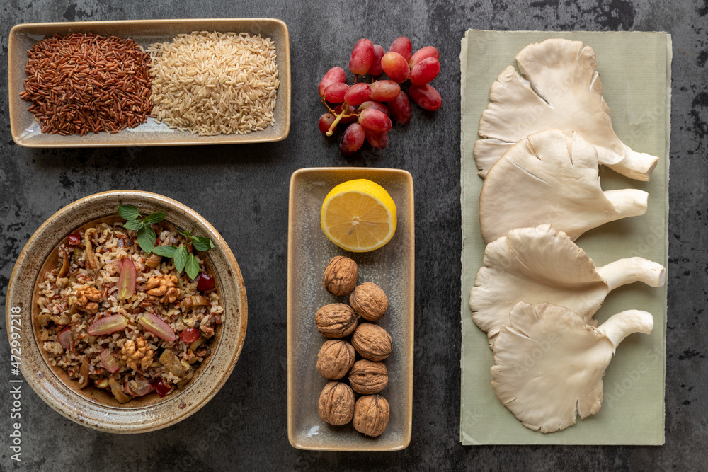 Vegan rice and oyster fungus meal with grapes and walnuts. Top view ...