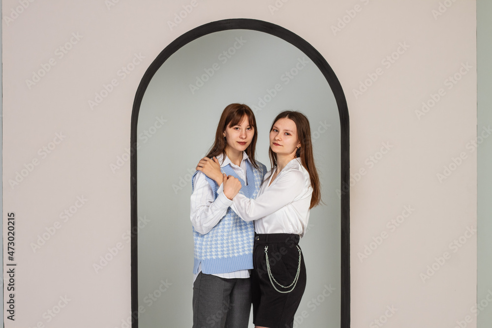 Two girls, girlfriends, sisters hug each other, stand next to shooting ...
