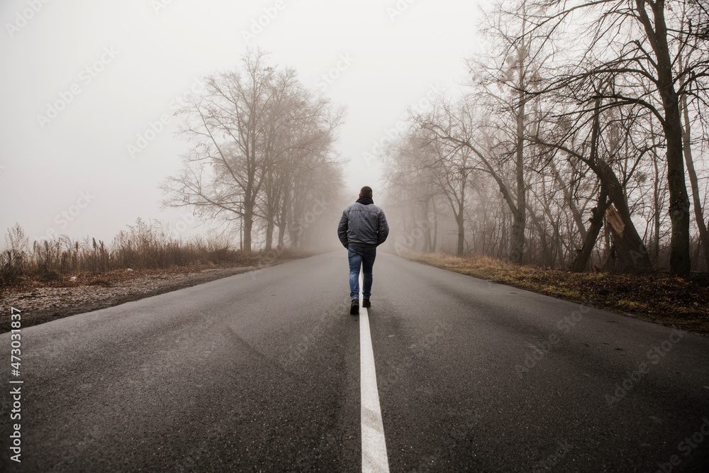 Man walking in a foggy autumn landscape. Lonely man walking in fog ...