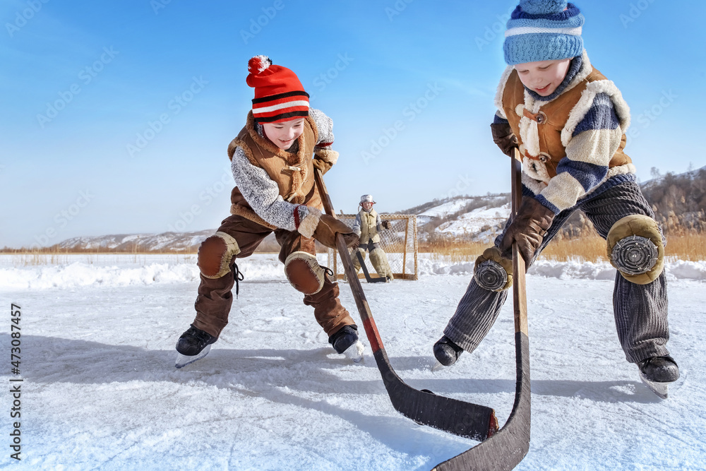Children play hockey. Team of young boys are engaged in active winter ...
