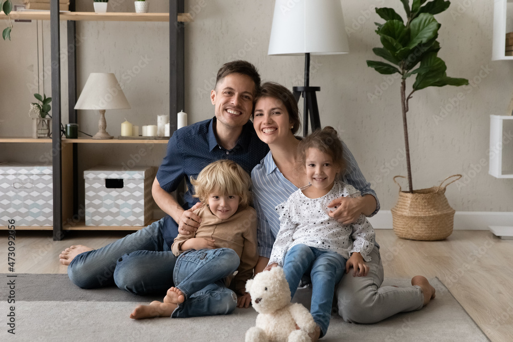 Happy parents and two little sibling kids home portrait. Millennial ...