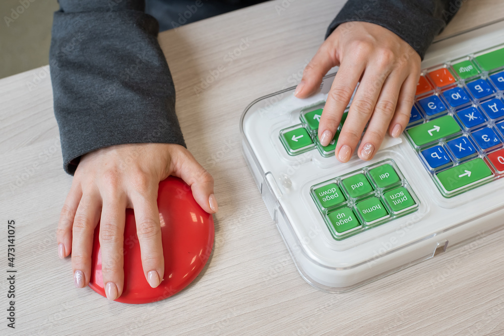 Woman with cerebral palsy working on a specialized wireless computer ...