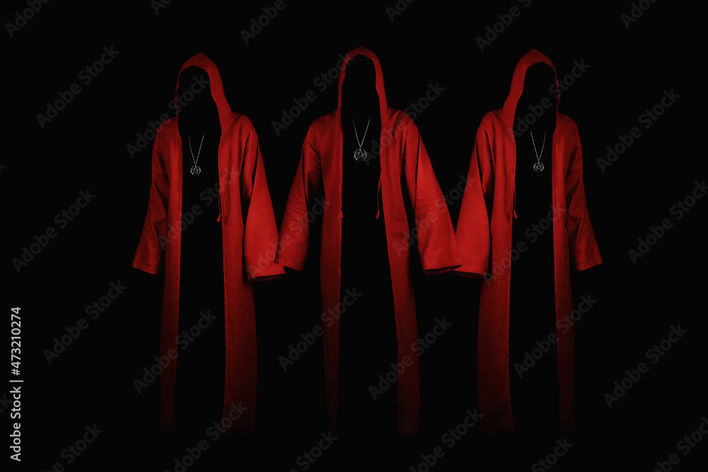 Group of mystery people in a red hooded cloaks. Unrecognizable person. Hiding face in shadow ...