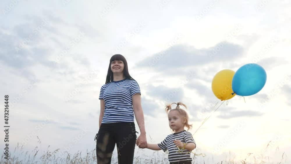 people in the park. happy family daughter and mom go strolling in with ...