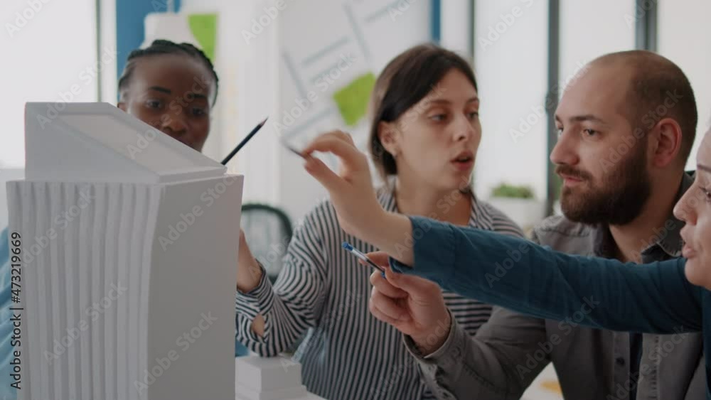 Close up of workmates analyzing building model and maquette on table to ...