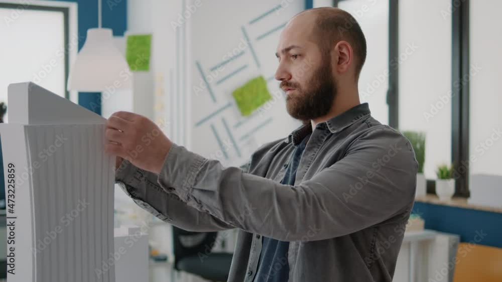 Close up of man architect looking at building model and maquette to ...