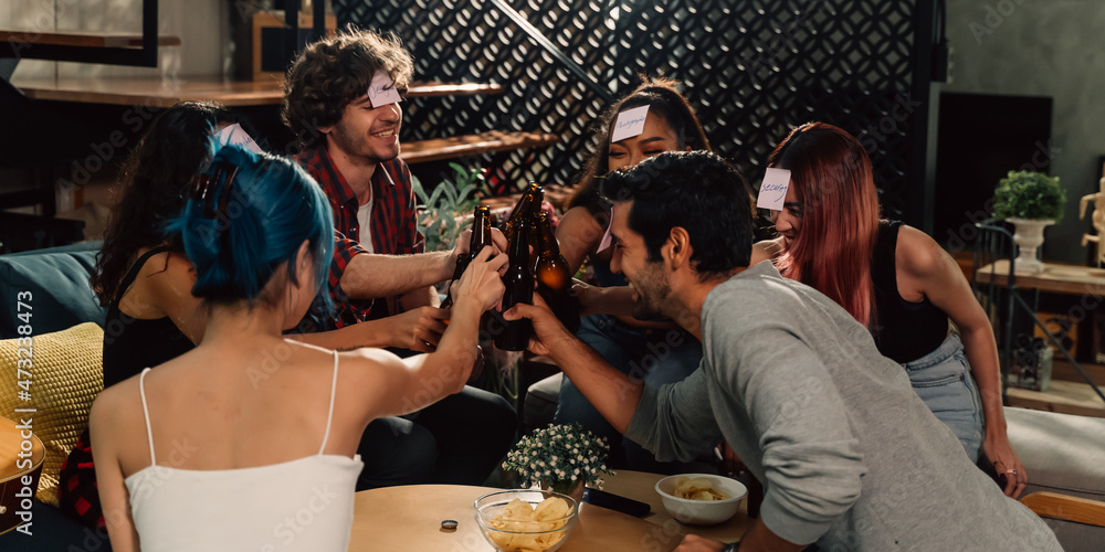 Diverse group of young people partying and toasting a drink in the ...