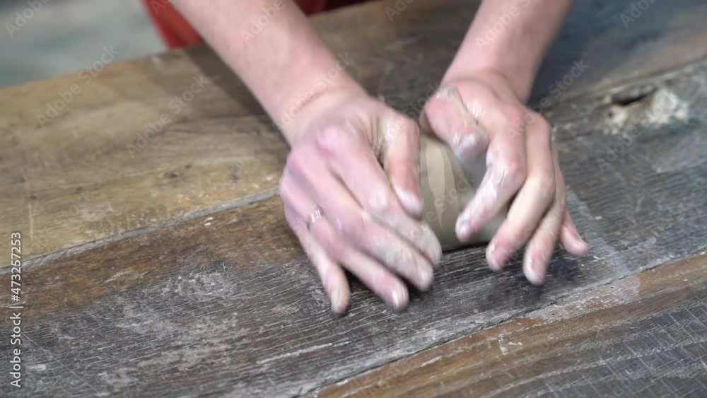 Kneading clay mound to remove air bubbles before being sculpted in the ...