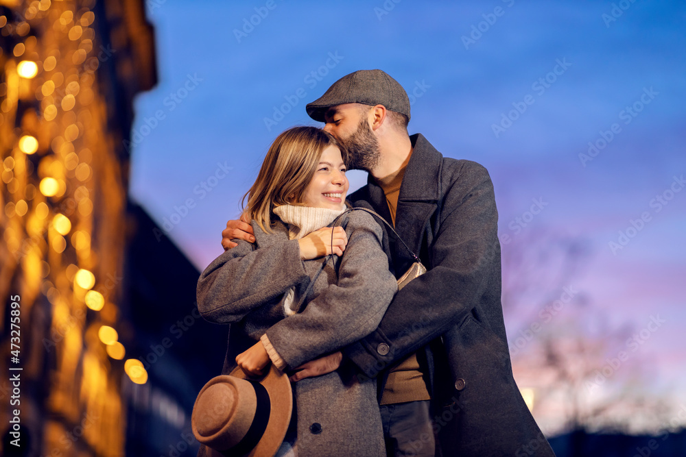 Affectionate lovers kissing on the street at dawn. A young happy lovers ...