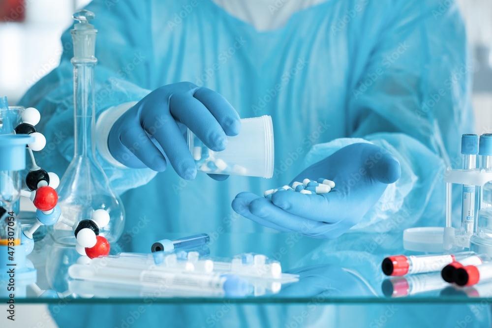 Scientist hands holding Omega 3 capsule in labcoat, doing experiments ...