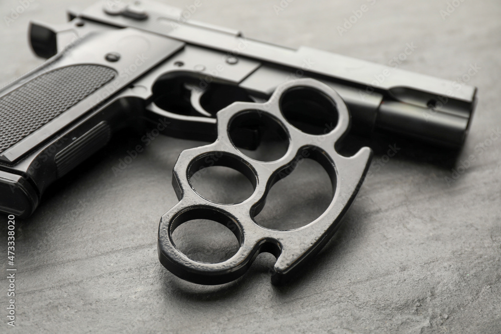 Brass knuckles and gun on black background, closeup Stock Photo | Adobe ...