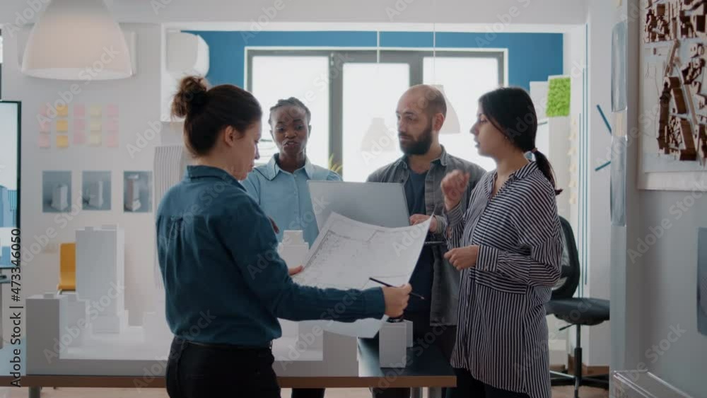 Multi ethnic group of architects working with blueprints and building ...