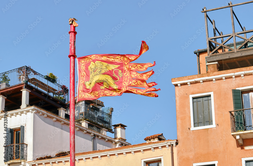Flag of Venice in a background of traditional Italian architecture, the ...